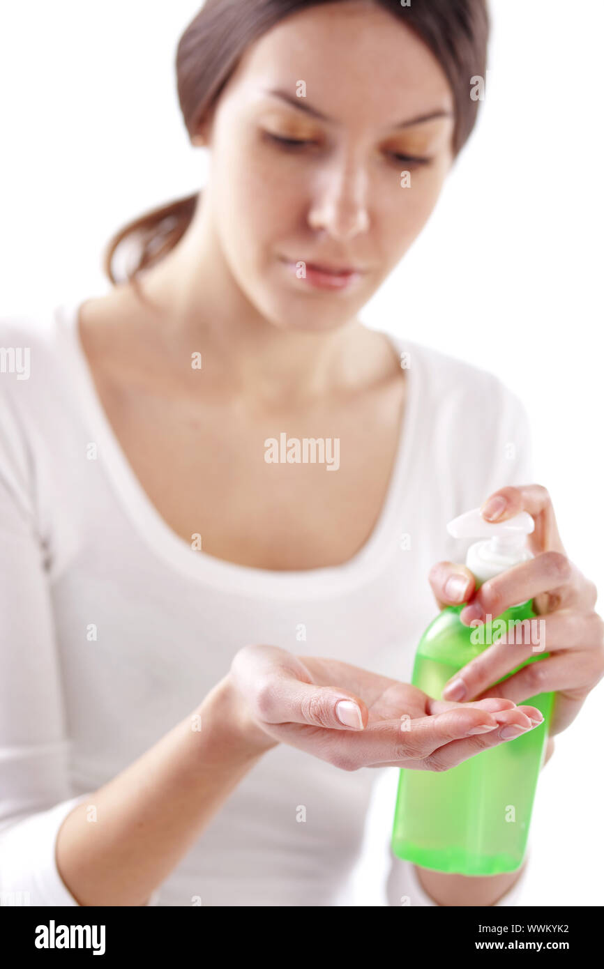Portrait of beautiful young woman applying face cosmetic products on ...