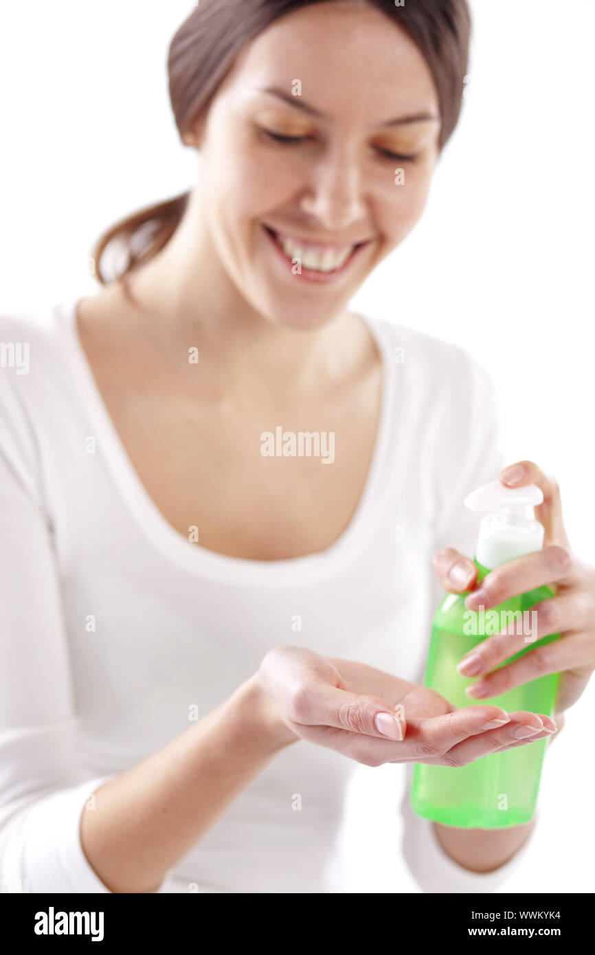 Portrait of beautiful young woman applying face cosmetic products on ...