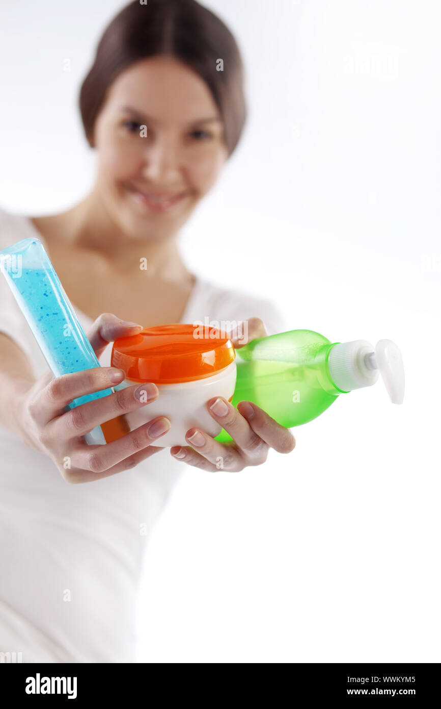 Portrait of beautiful young woman applying face cosmetic products on ...