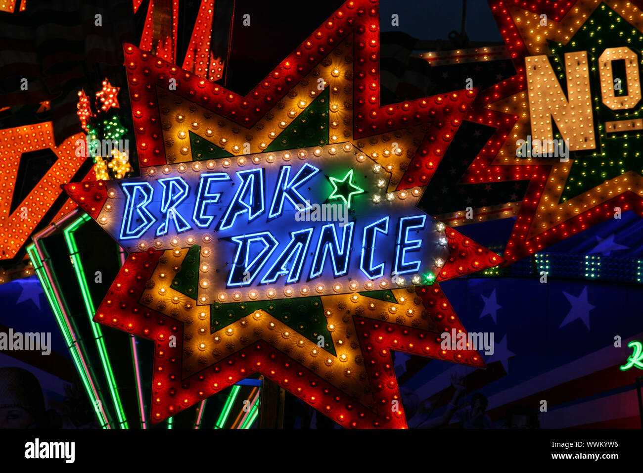 Neon fun fair attraction advertising at night Stock Photo - Alamy