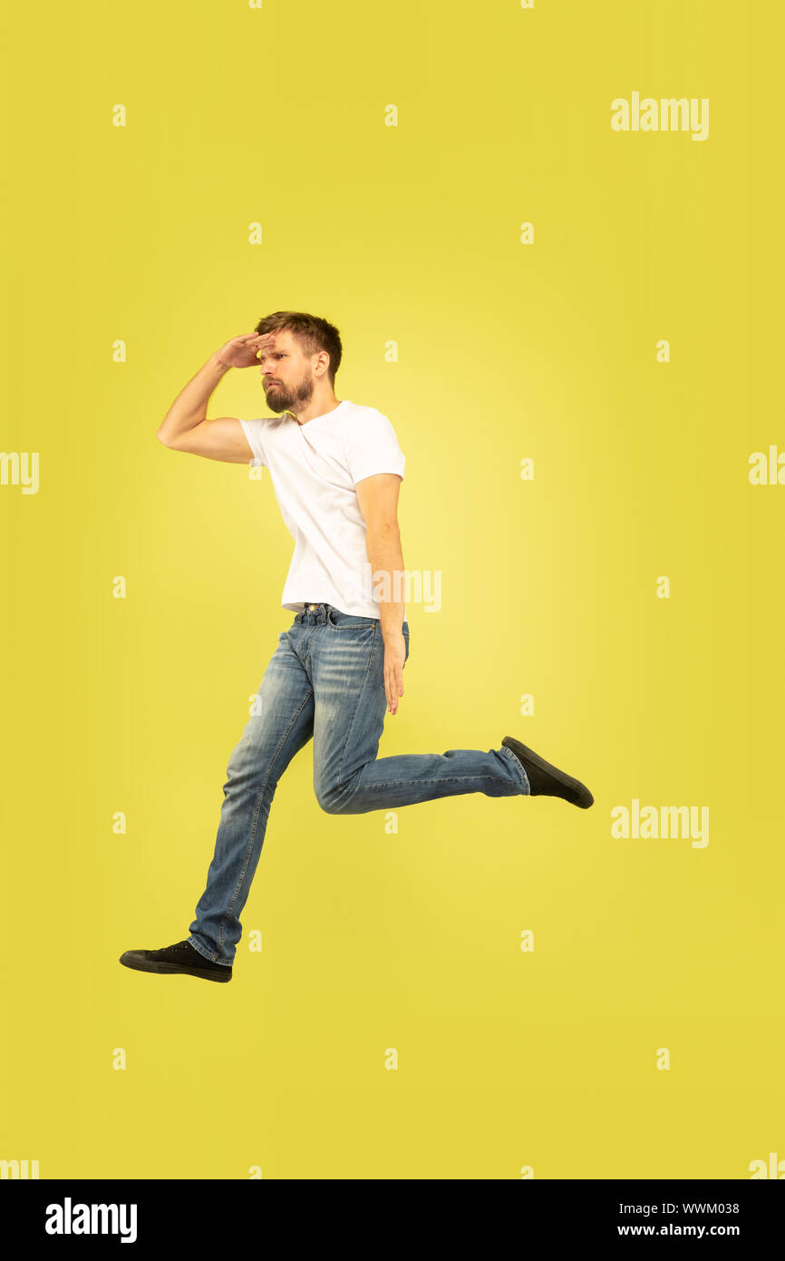 Full length portrait of happy jumping man isolated on yellow background ...
