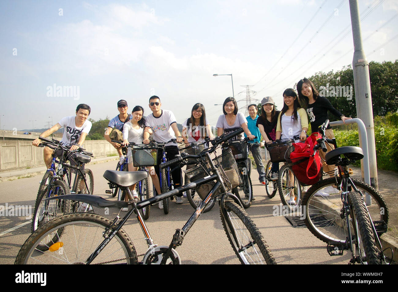 Asian friends riding bicycle Stock Photo - Alamy