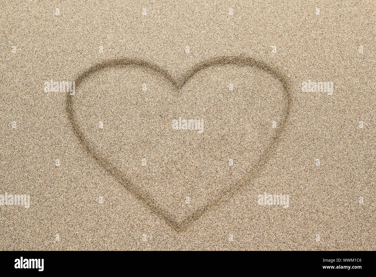 Heart shape symbol drawn in sand Stock Photo - Alamy