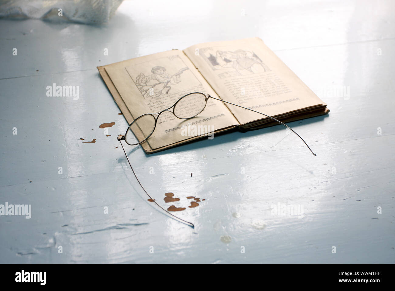 old fashioned reading glasses on top of an old book on a table Stock ...