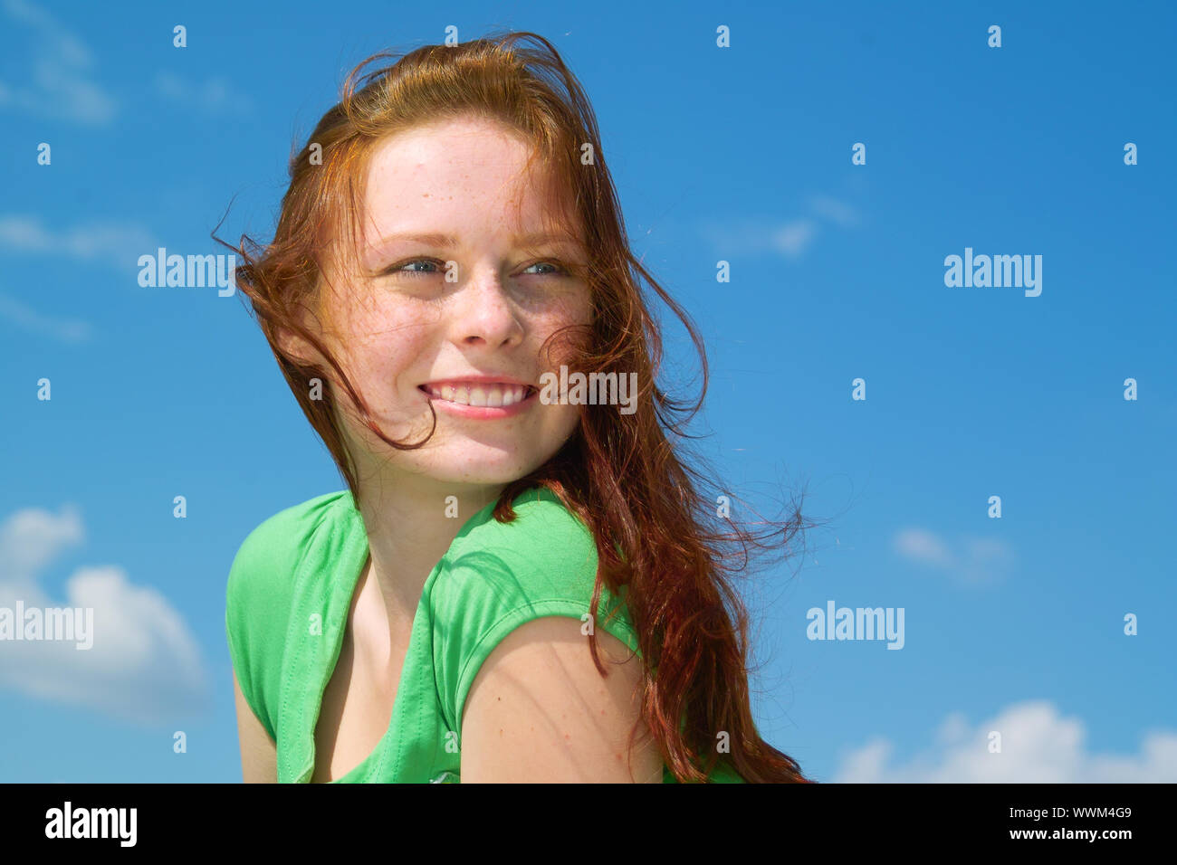 Beautiful lady in green smiling over sky Stock Photo - Alamy