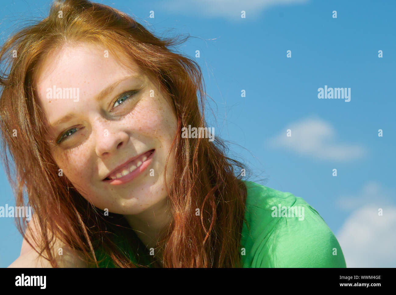 Beautiful lady in green smiling over sky Stock Photo - Alamy