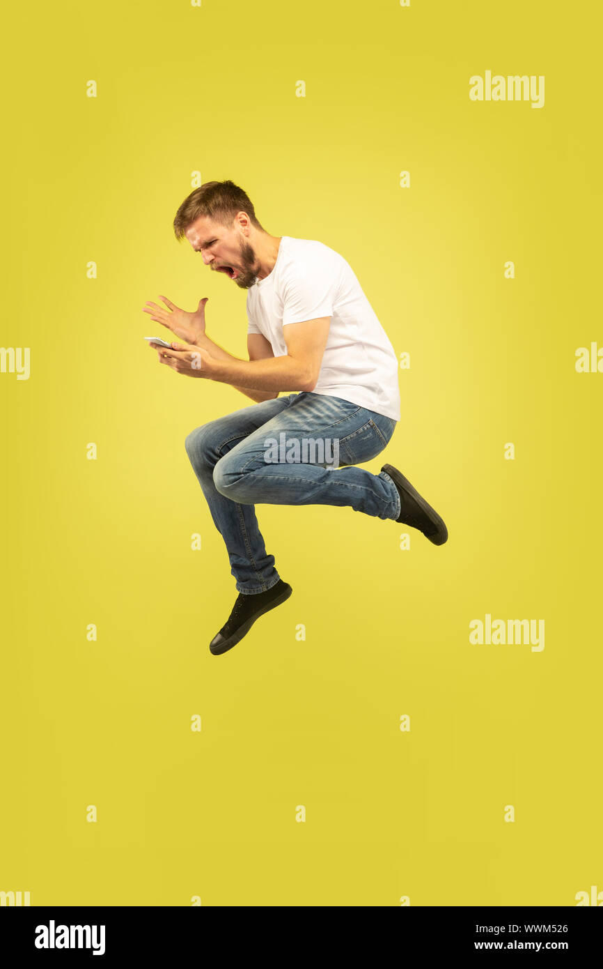 Full length portrait of happy jumping man isolated on yellow background ...