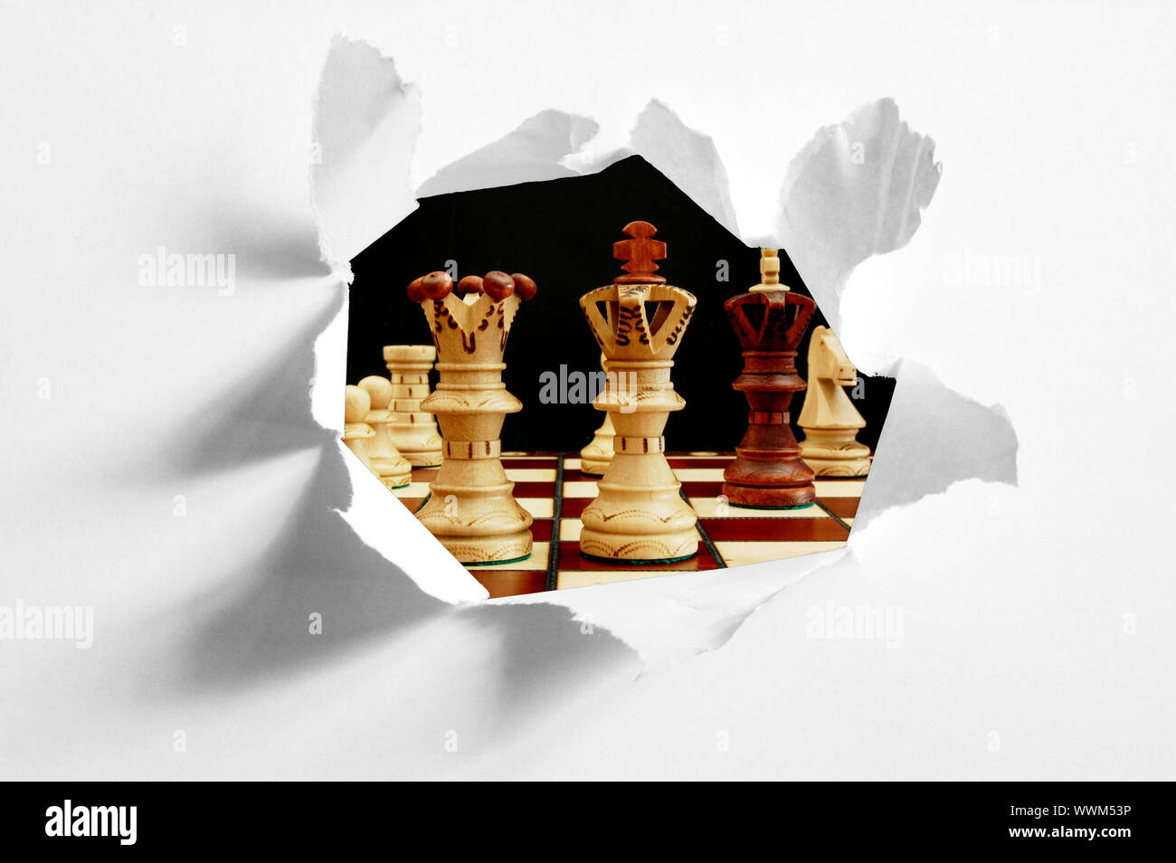 chess pieces behind hole in blank paper Stock Photo - Alamy