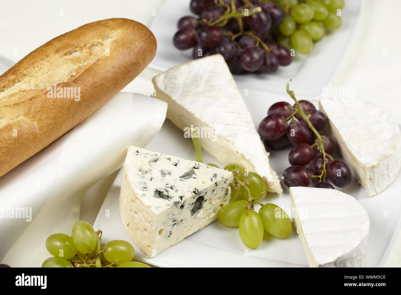 Cheese platter with baguette and grapes Stock Photo - Alamy