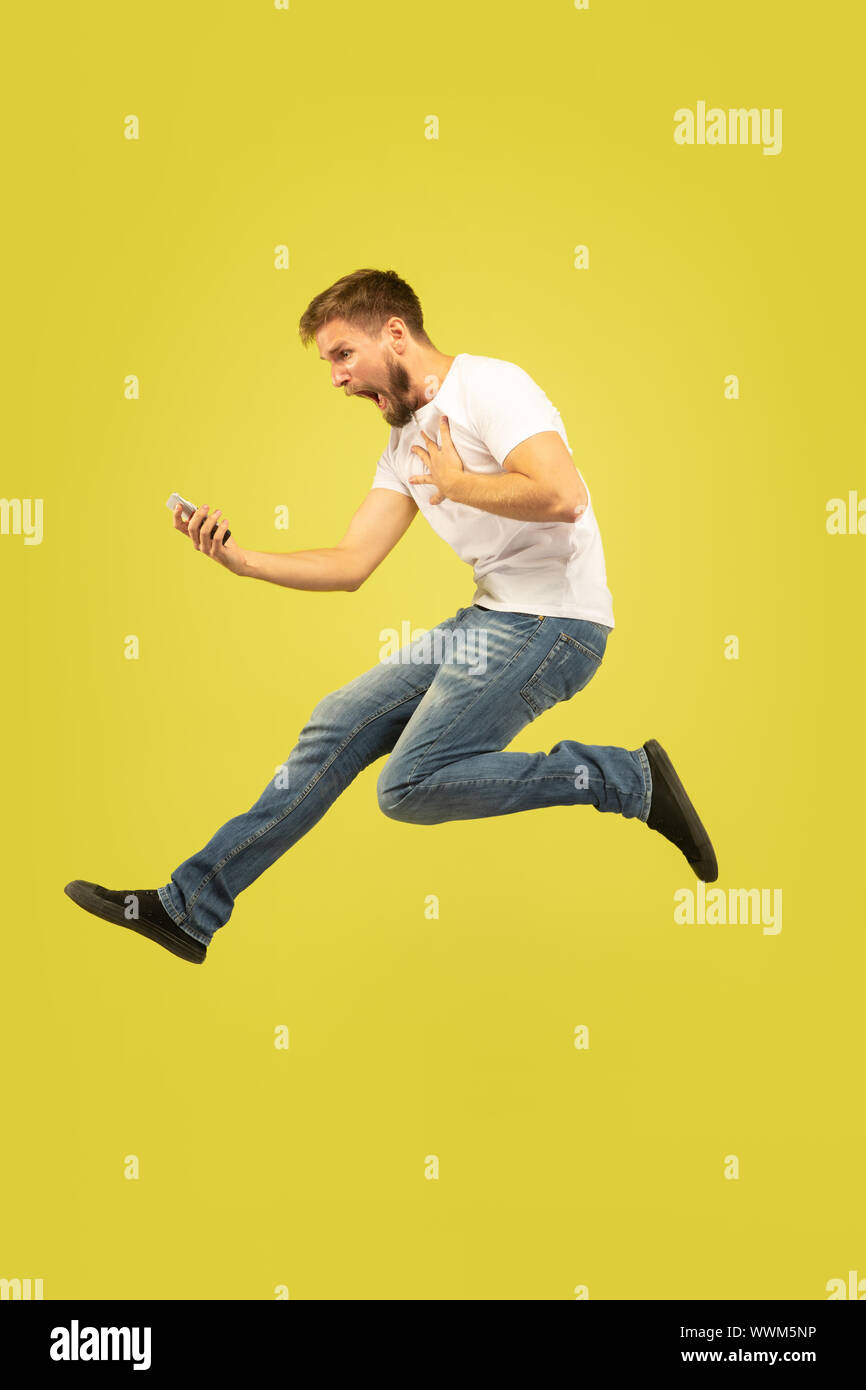 Full length portrait of happy jumping man isolated on yellow background ...