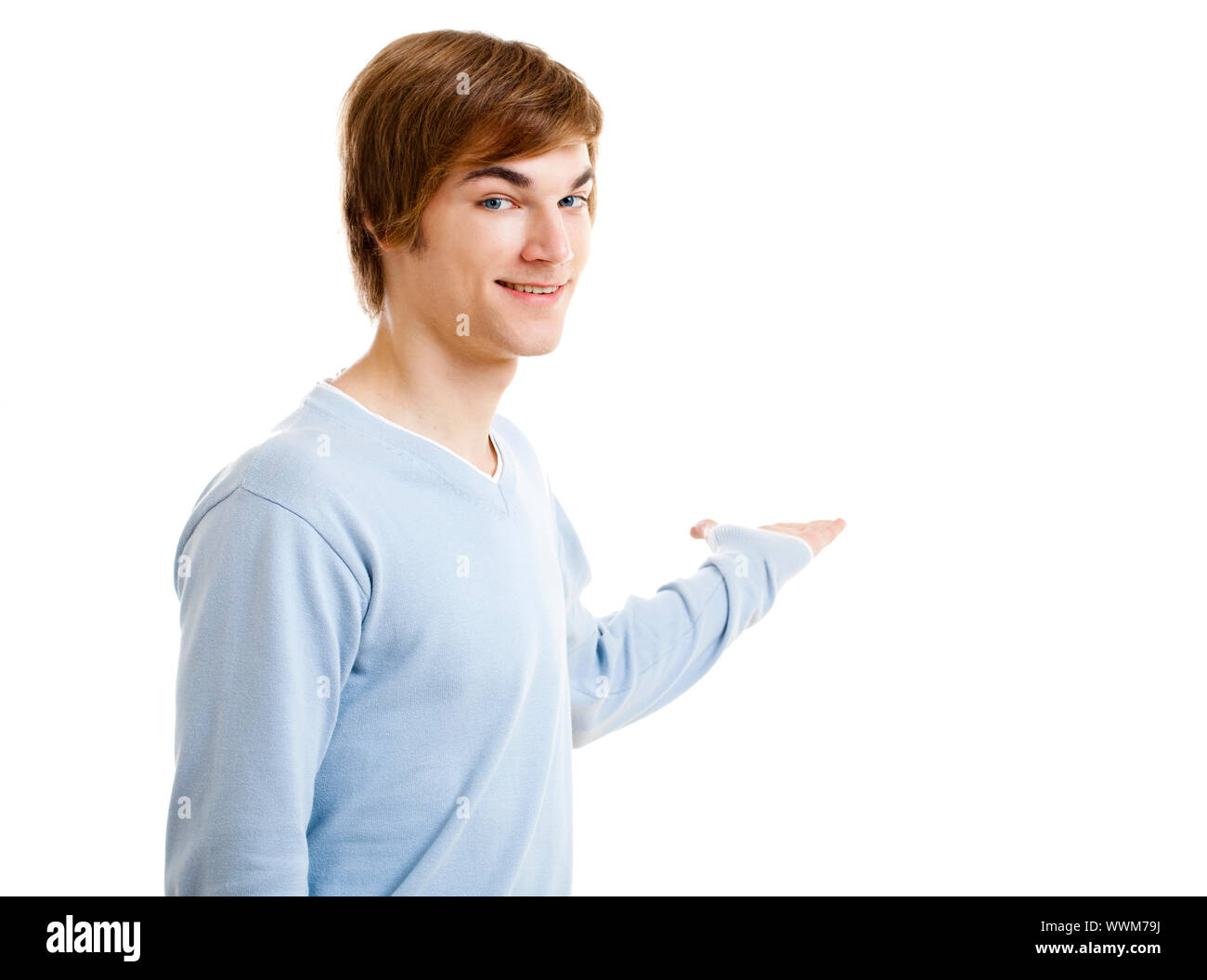 Happy young man showing something and pointing, isolated over a white ...