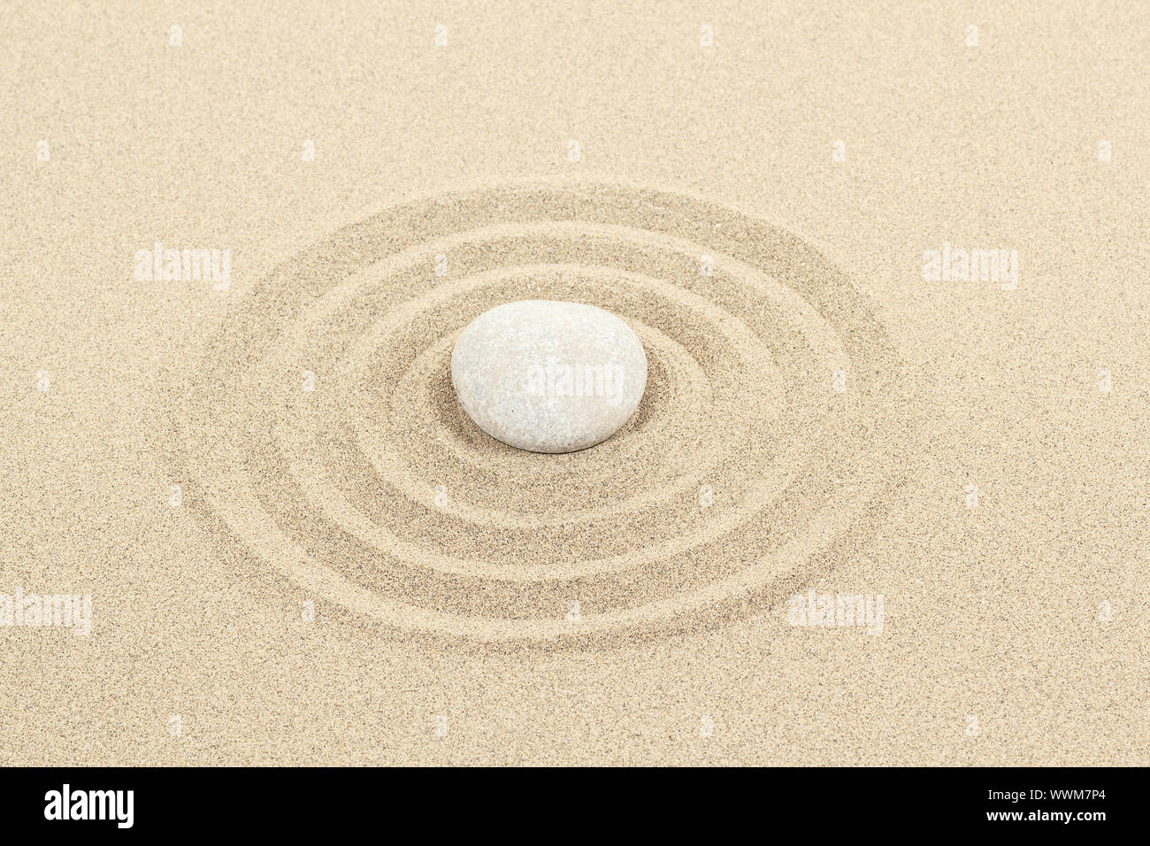 zen stone in sand with circles Stock Photo - Alamy