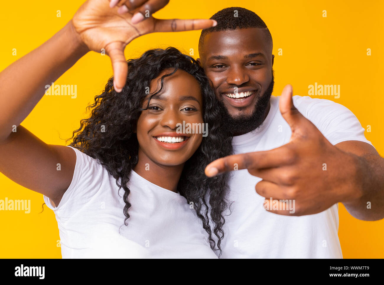 Black man and woman showing frame sign with hands Stock Photo - Alamy