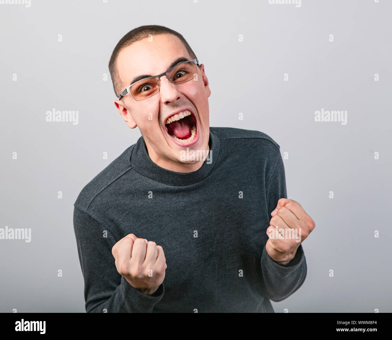 Angry young man shouting with open mouth and very anger face, showing ...