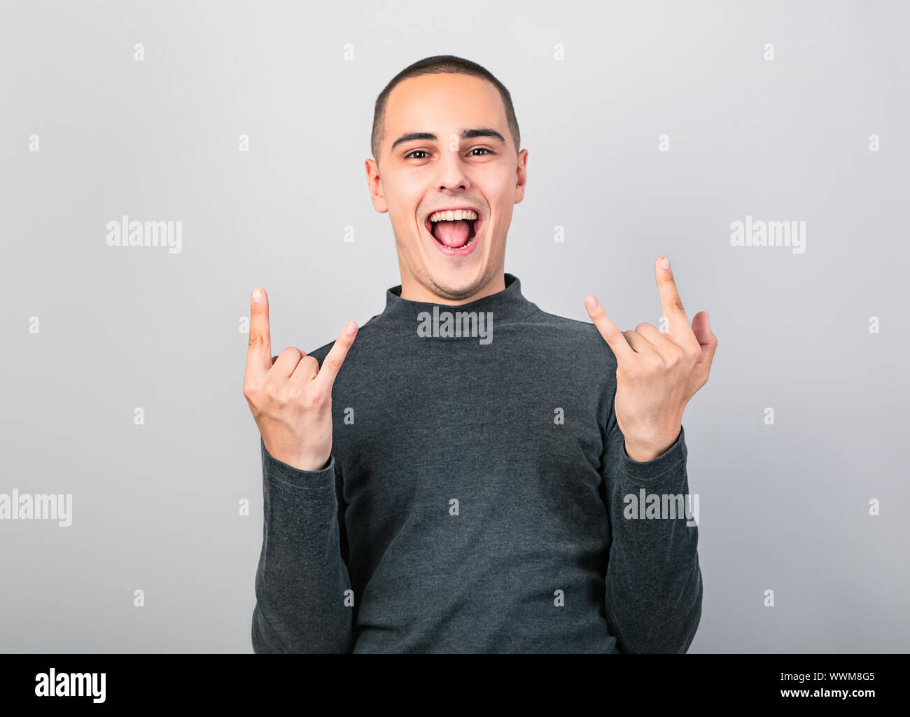 Crazy grimacing man showing the rock sign by two hands with crying open ...