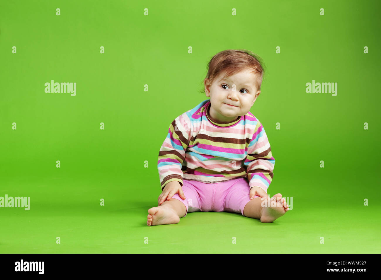 Cute baby on studio green background Stock Photo - Alamy