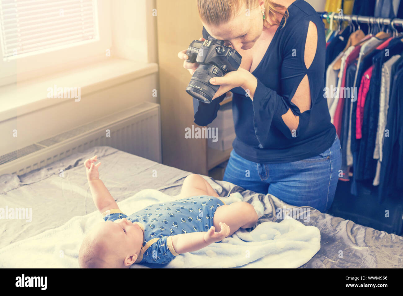 Side top view of mother taking a picture of her baby by DSLR camera ...