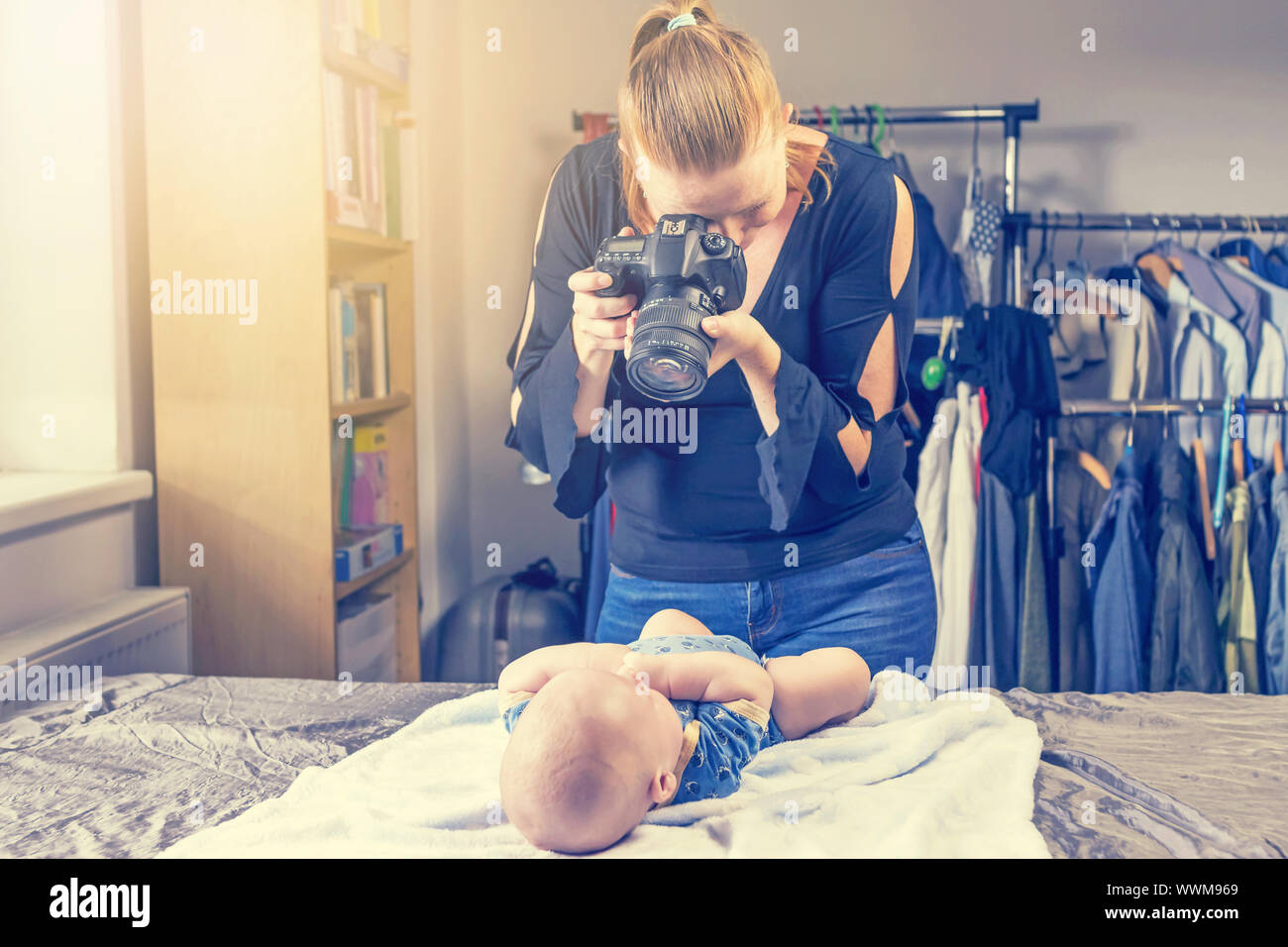 Mother is taking a picture of her baby by a DSLR camera. Concept photo ...