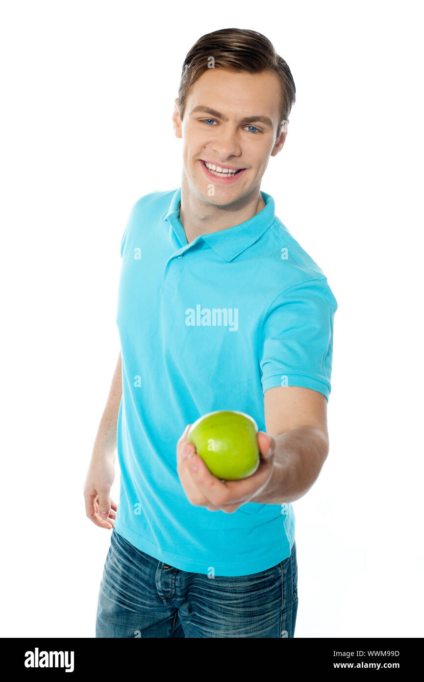 Good looking healthy guy offering a green apple isoalted over white ...