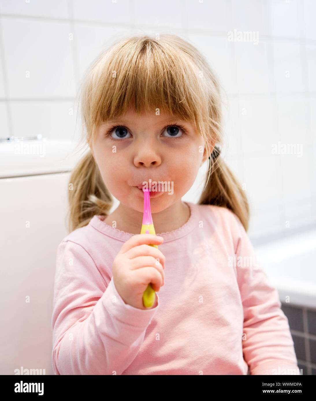 Baby Girl with toothbrush in the bathroom Stock Photo - Alamy