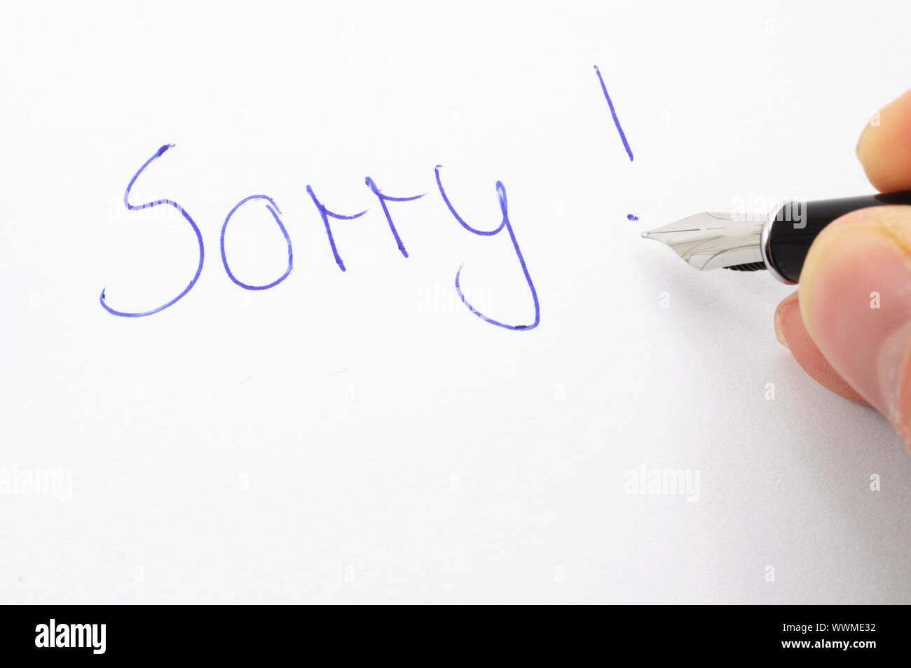 say sorry with a text message on paper and pen Stock Photo - Alamy