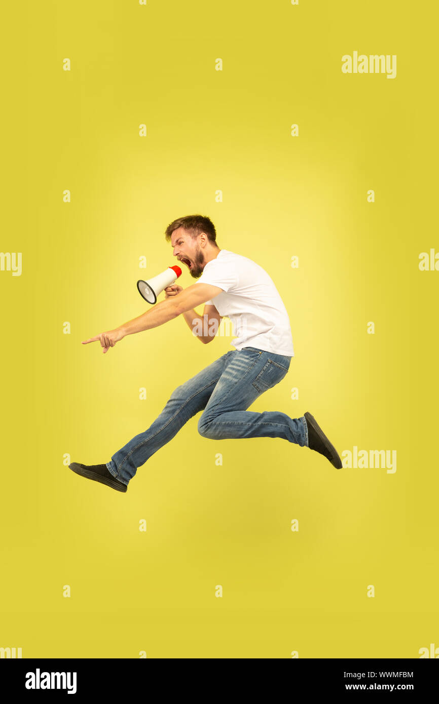 Full length portrait of happy jumping man isolated on yellow background ...