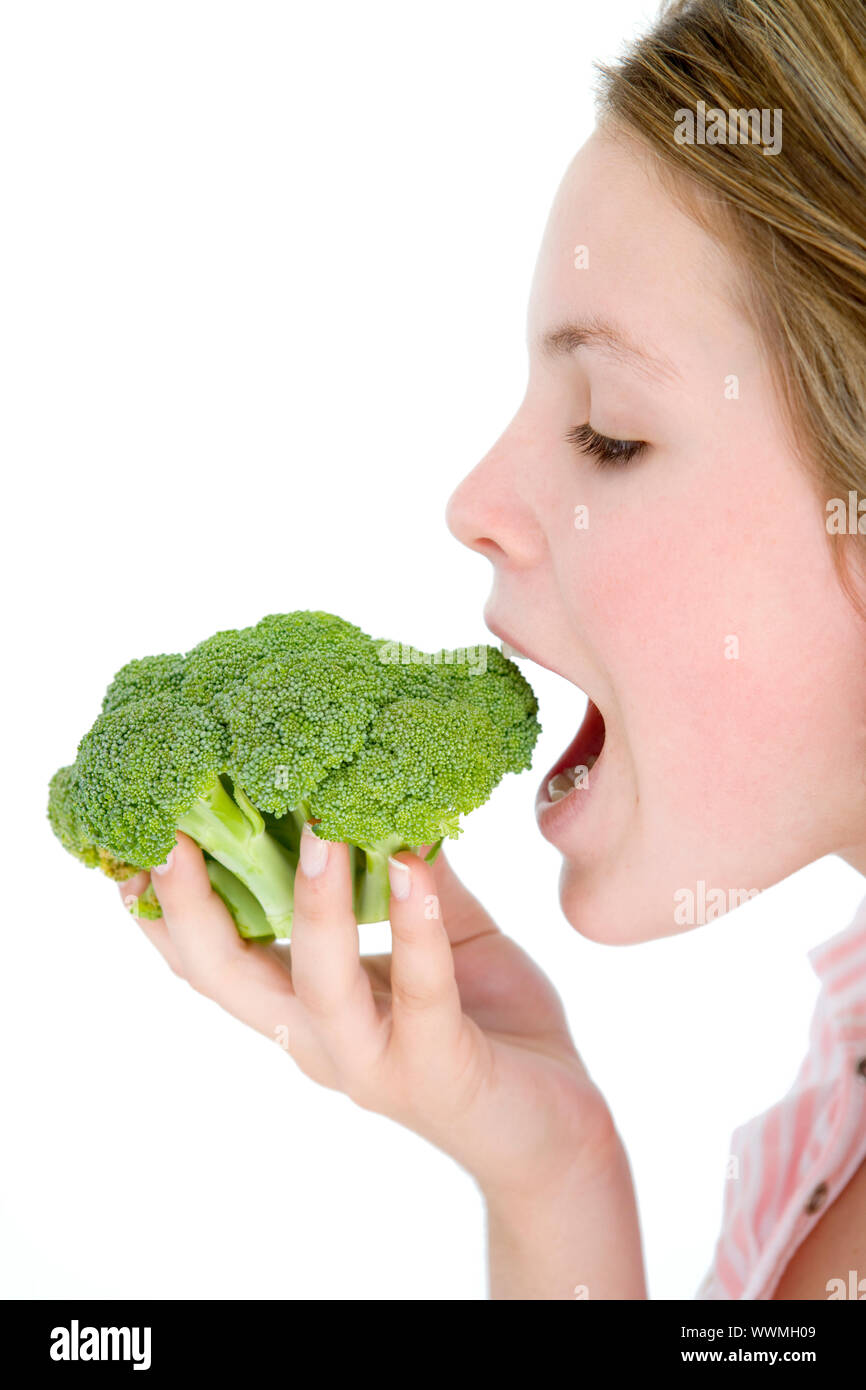 Teenage girl eating broccoli Stock Photo - Alamy