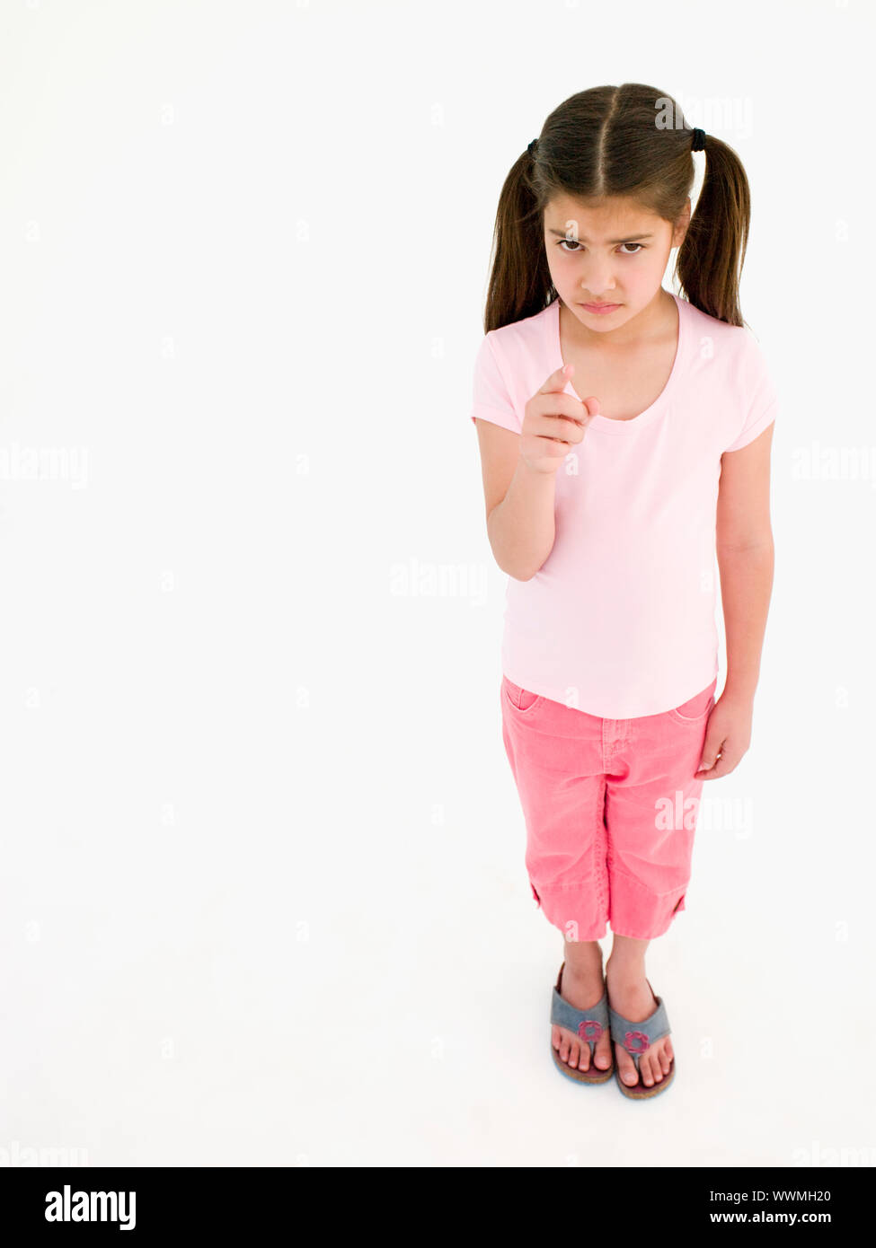 Young girl pointing and frowning Stock Photo - Alamy