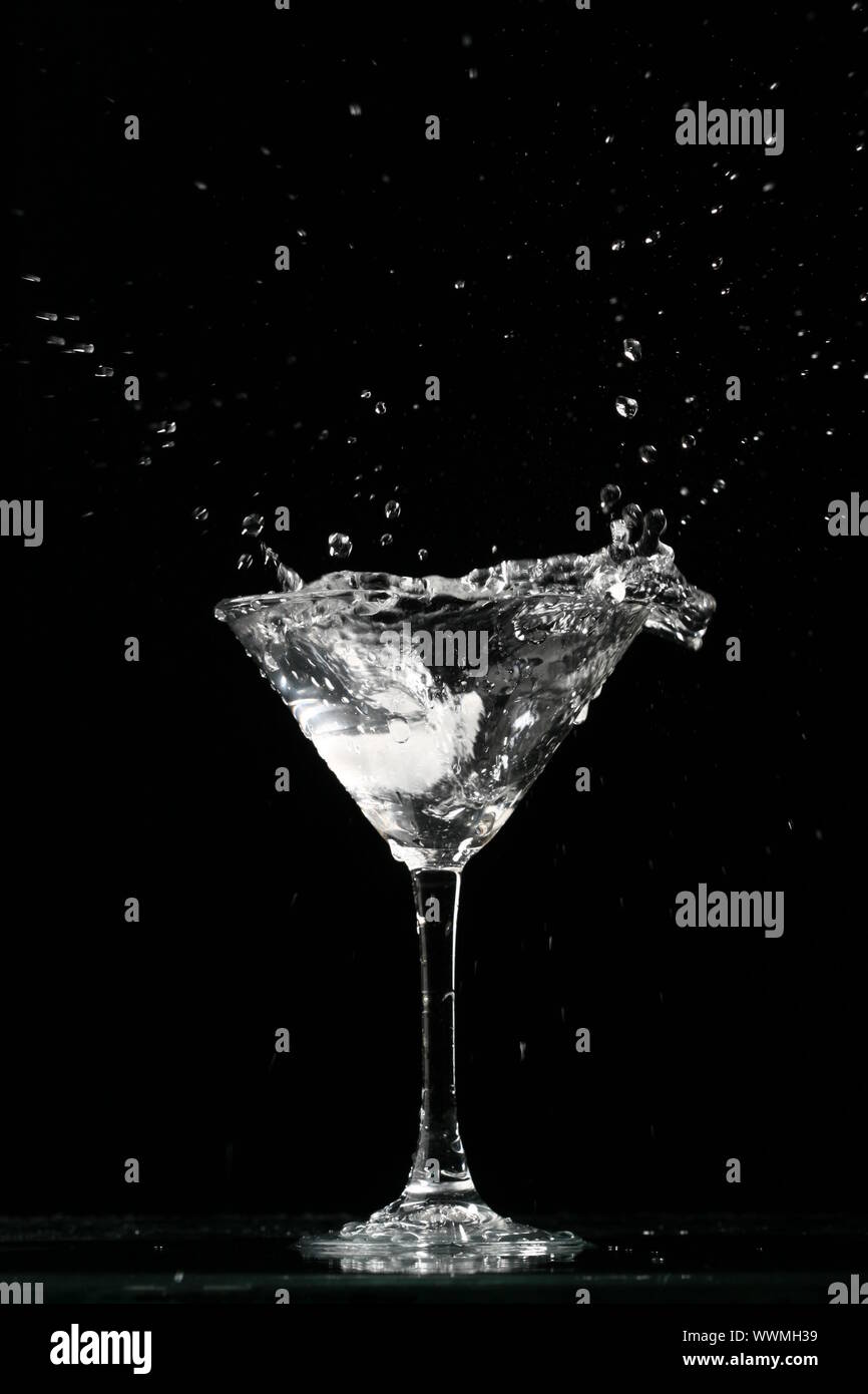 alcohol splash on black background Stock Photo - Alamy