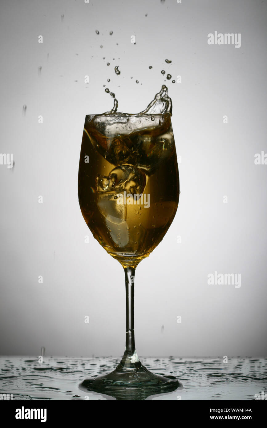 alcohol splash on gray background Stock Photo - Alamy