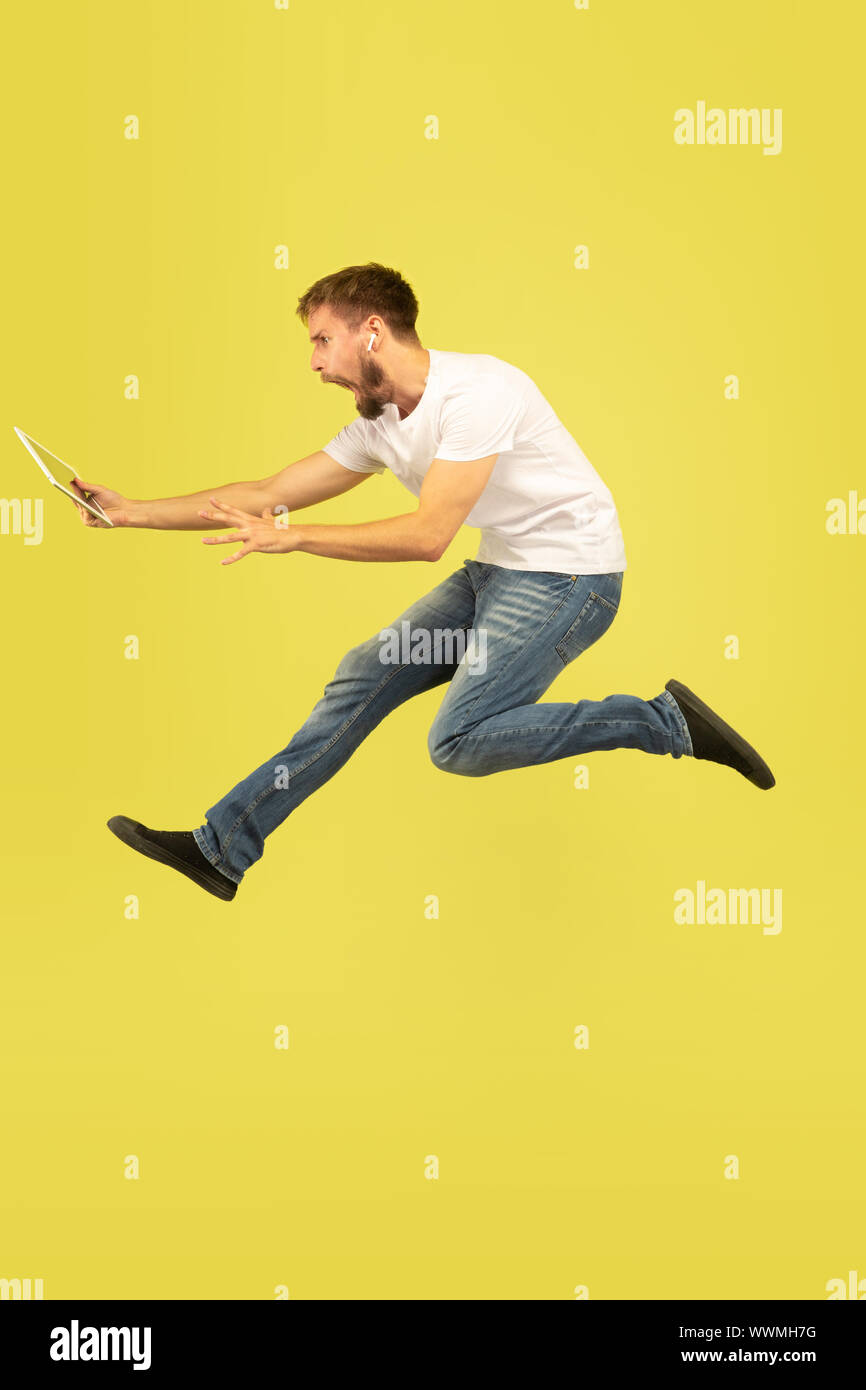 Full length portrait of happy jumping man isolated on yellow background ...