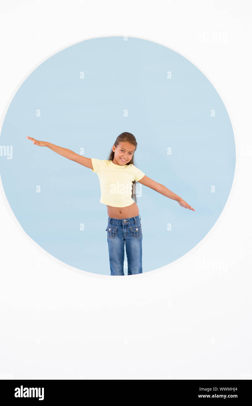 Young girl standing with arms out smiling Stock Photo - Alamy
