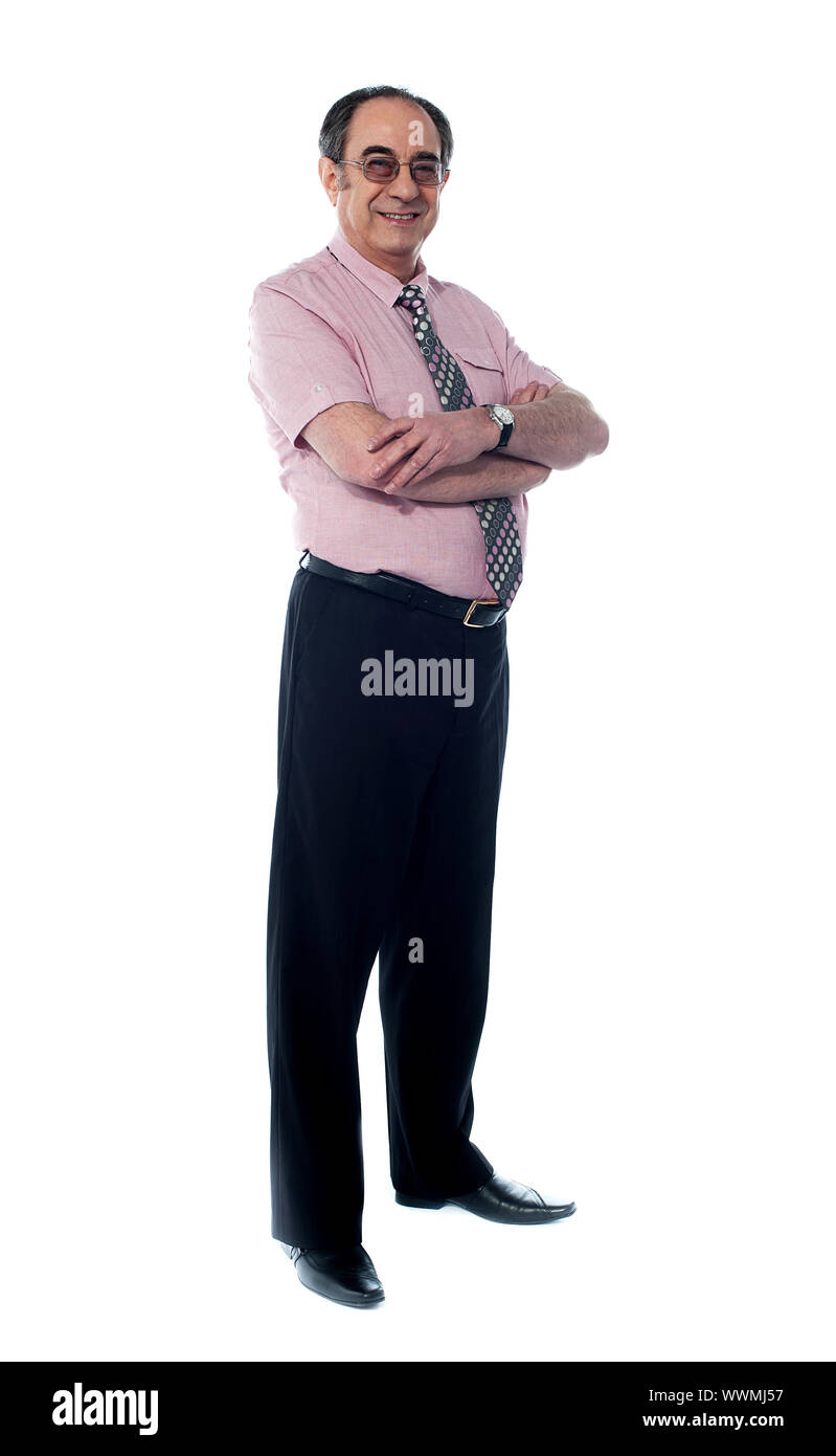 Senior business associate smiling as he poses with folded arms against ...
