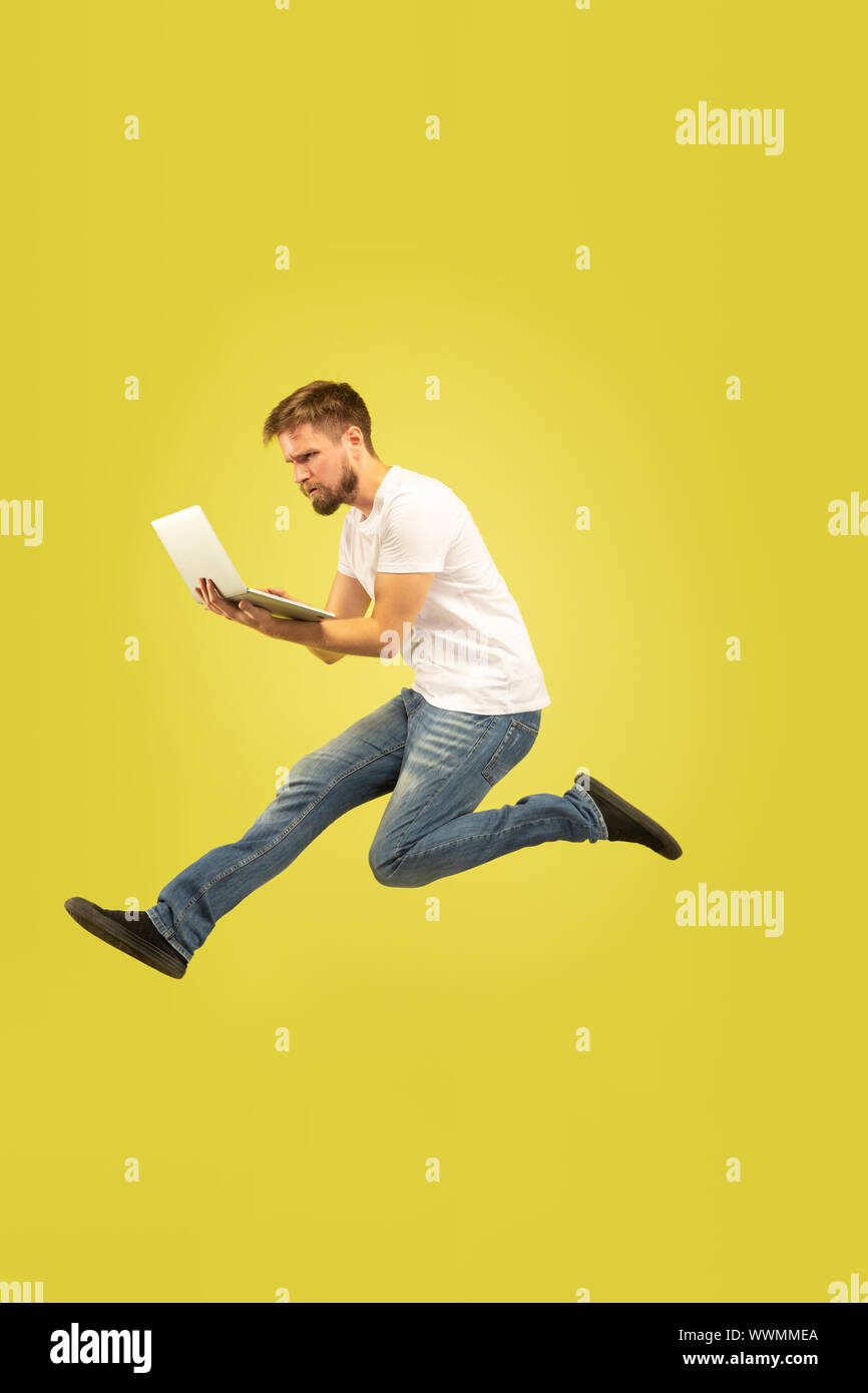 Full length portrait of happy jumping man isolated on yellow background ...