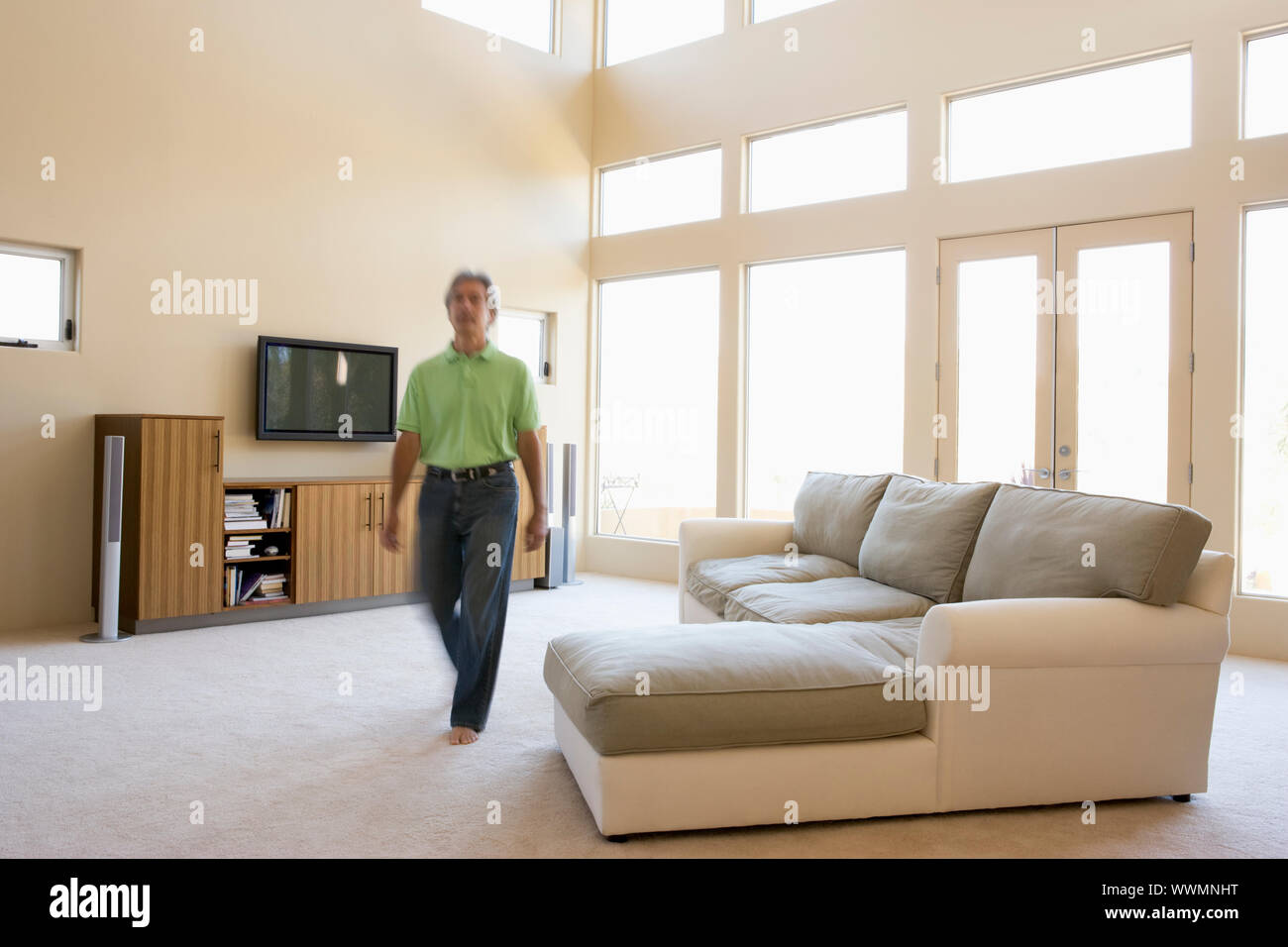 Man walking through living room Stock Photo - Alamy