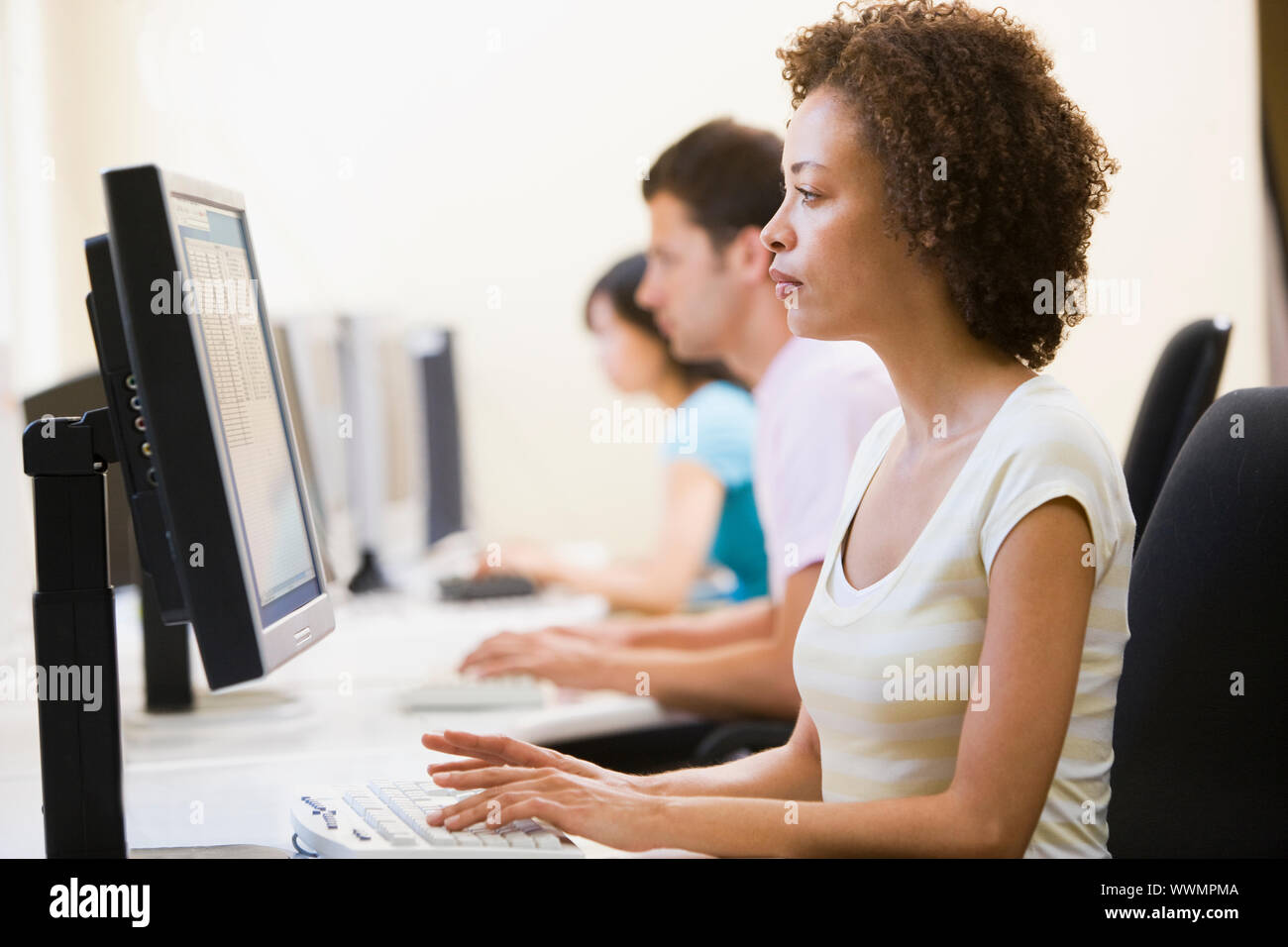 Three people in computer room typing Stock Photo - Alamy