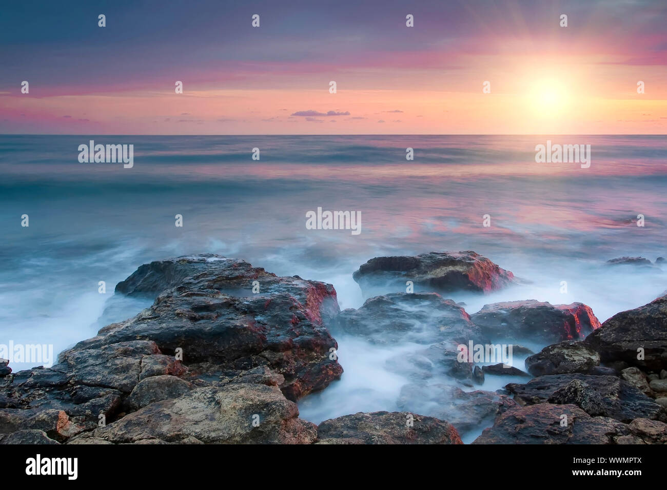 Beautiful rocky sea beach at the sunset Stock Photo - Alamy