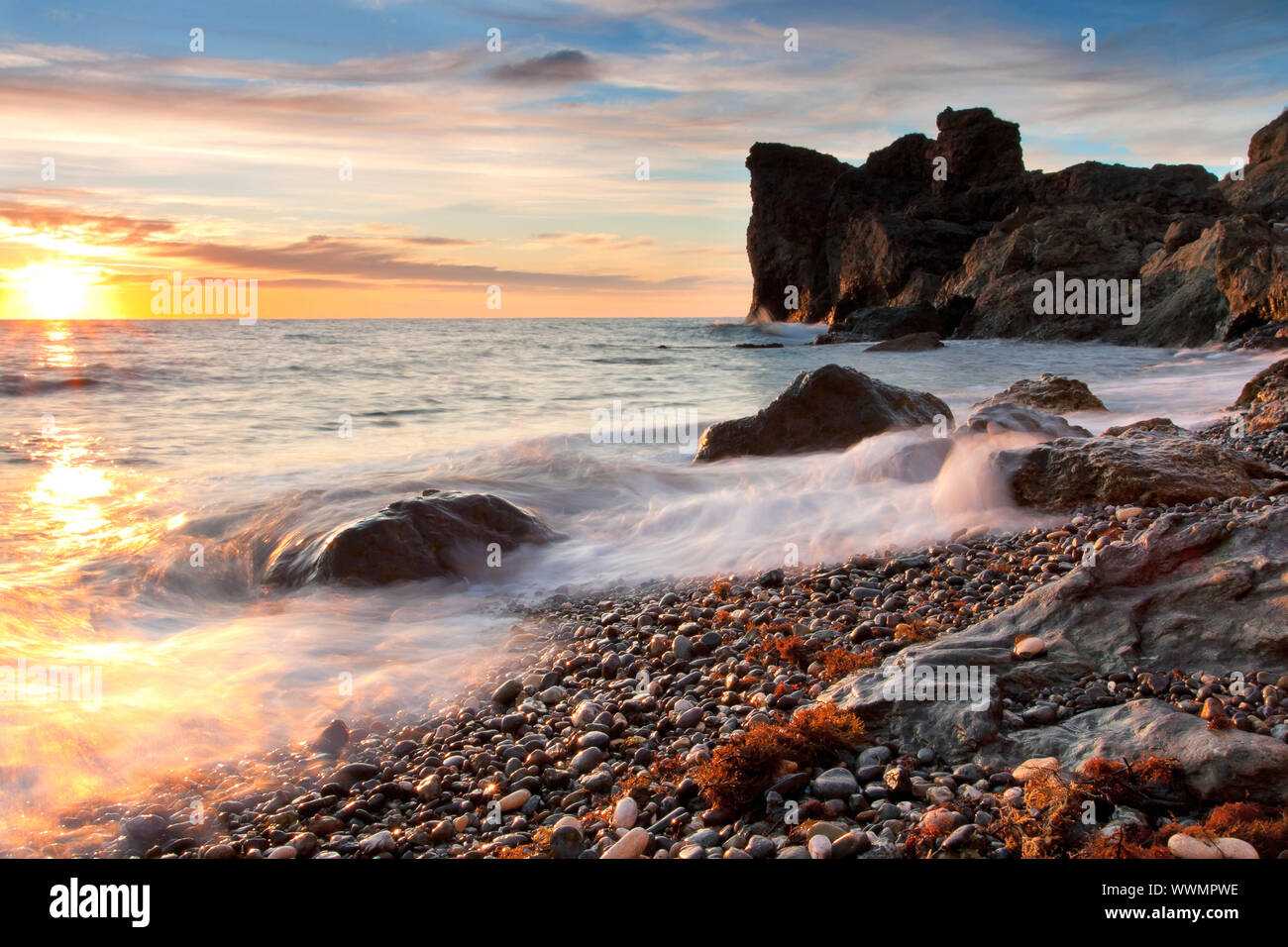 Beautiful rocky sea beach at the sunset Stock Photo - Alamy