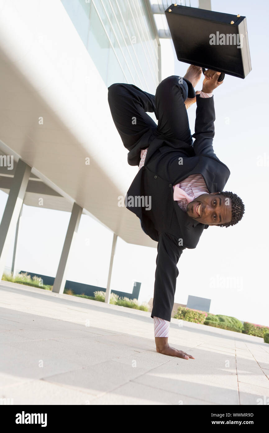 Businessman outdoors by building standing on one hand smiling Stock ...
