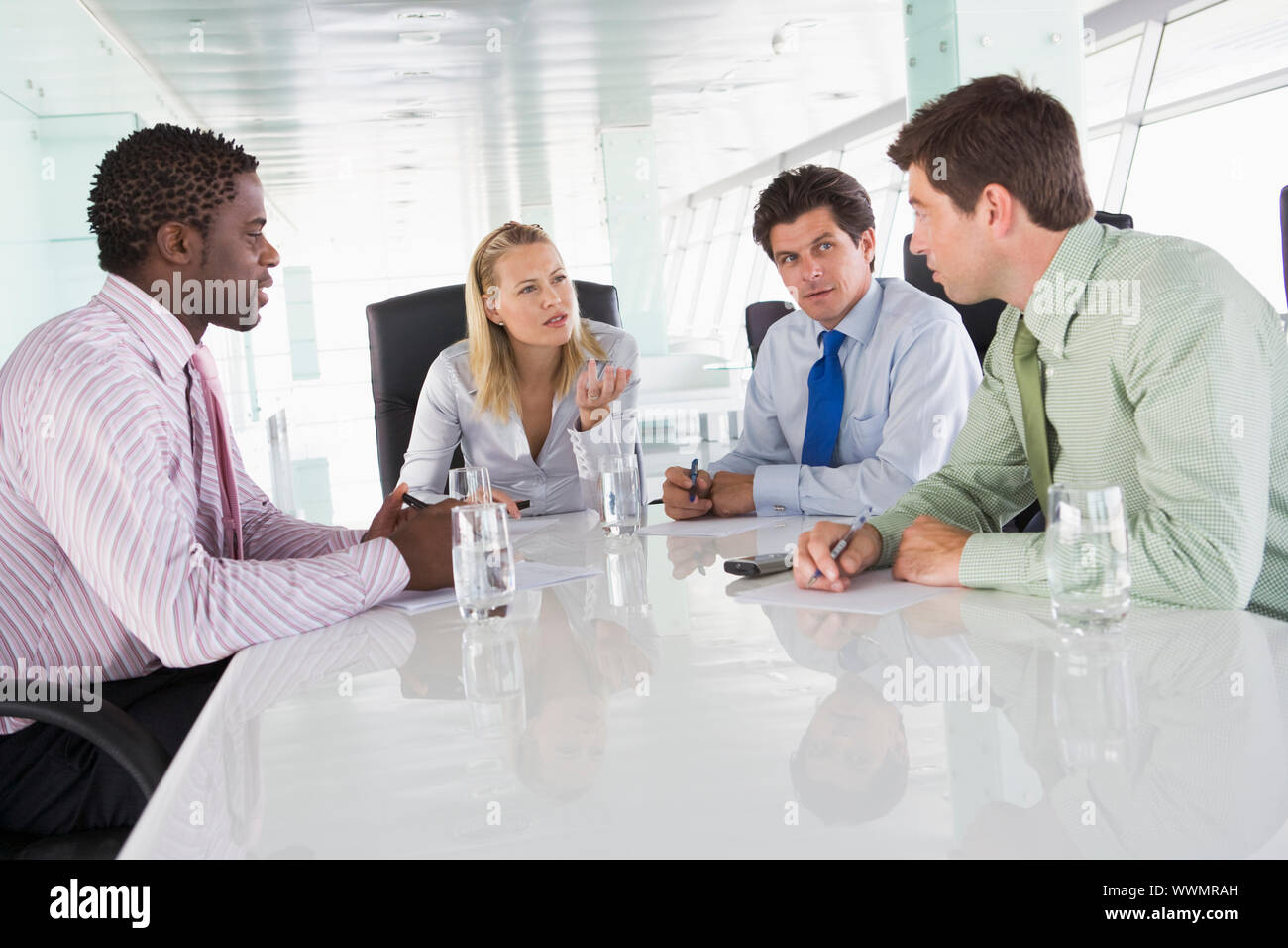 Four businesspeople in a boardroom talking Stock Photo - Alamy