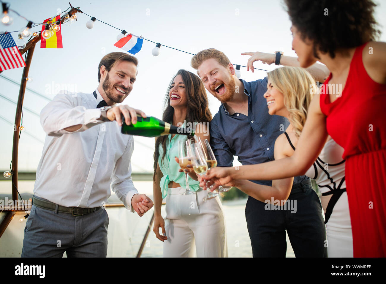 Group of happy friends partying and toasting drinks Stock Photo - Alamy