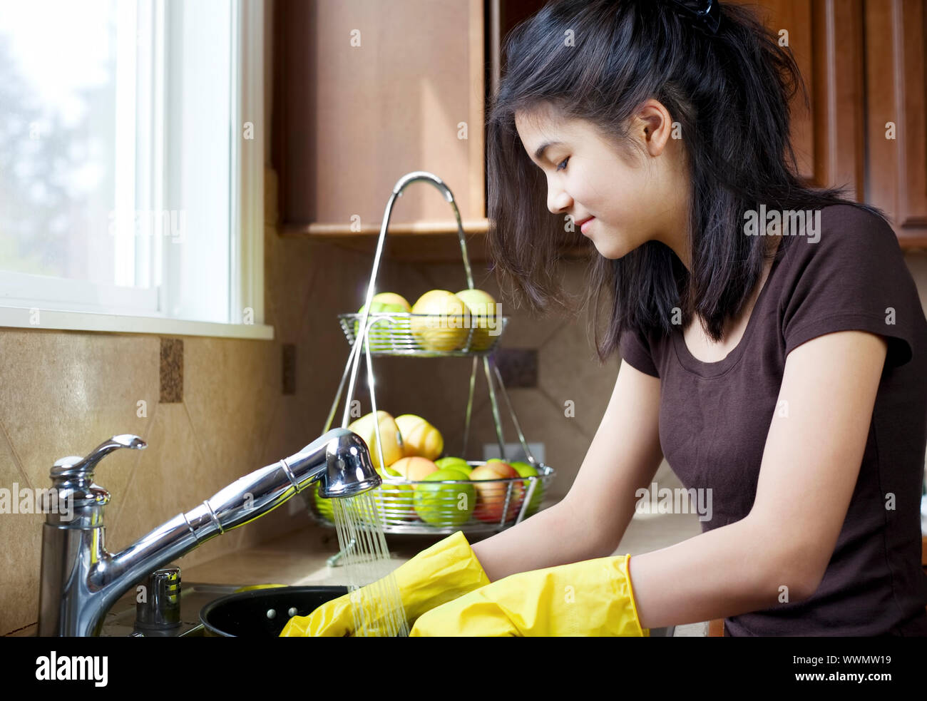 Teen girl washing dishes at kitchen sink Stock Photo - Alamy