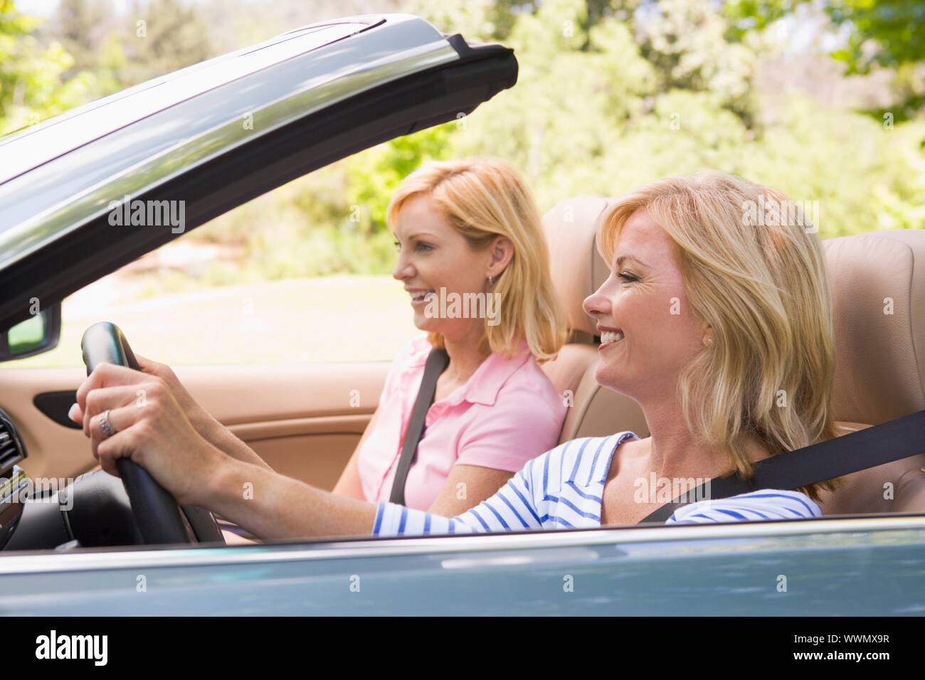 Two women in convertible car smiling Stock Photo - Alamy