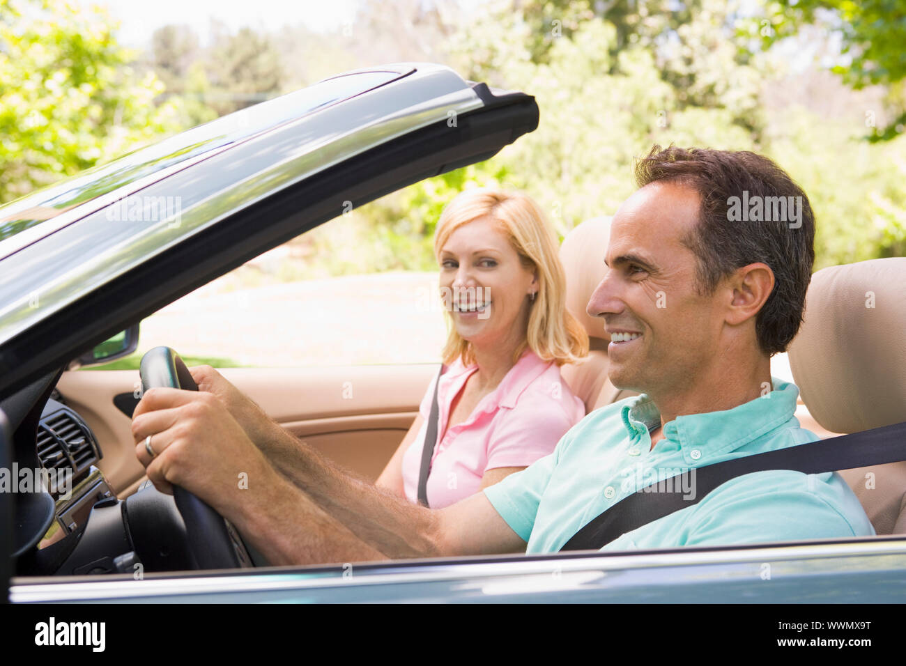 Couple in convertible car smiling Stock Photo - Alamy
