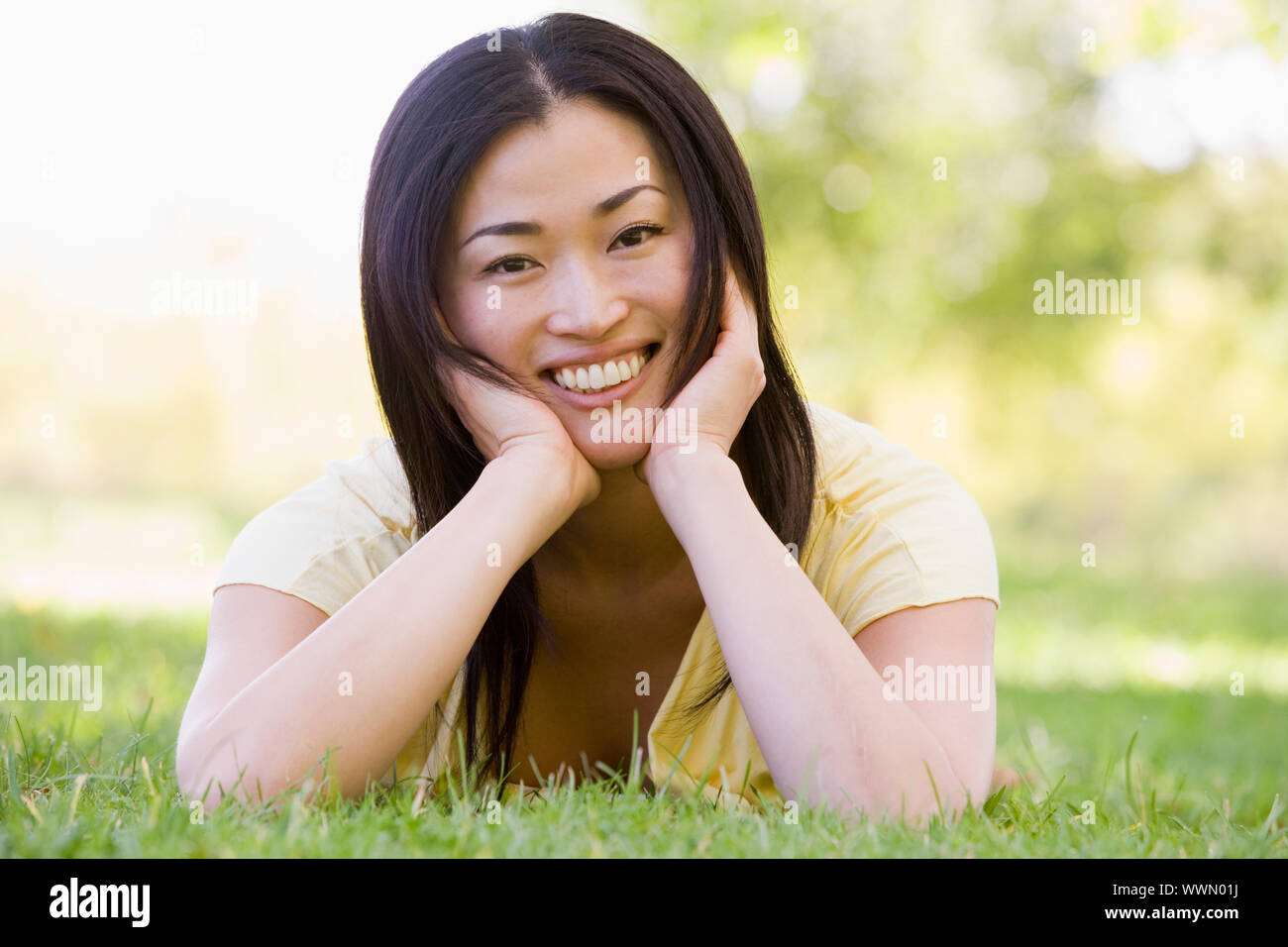 Woman lying outdoors smiling Stock Photo - Alamy