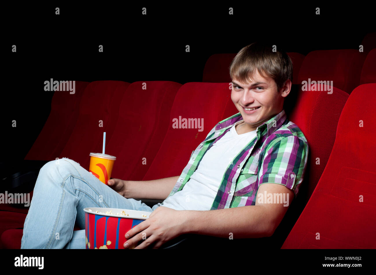 man in a movie theater, watching a movie and drink a drink Stock Photo ...