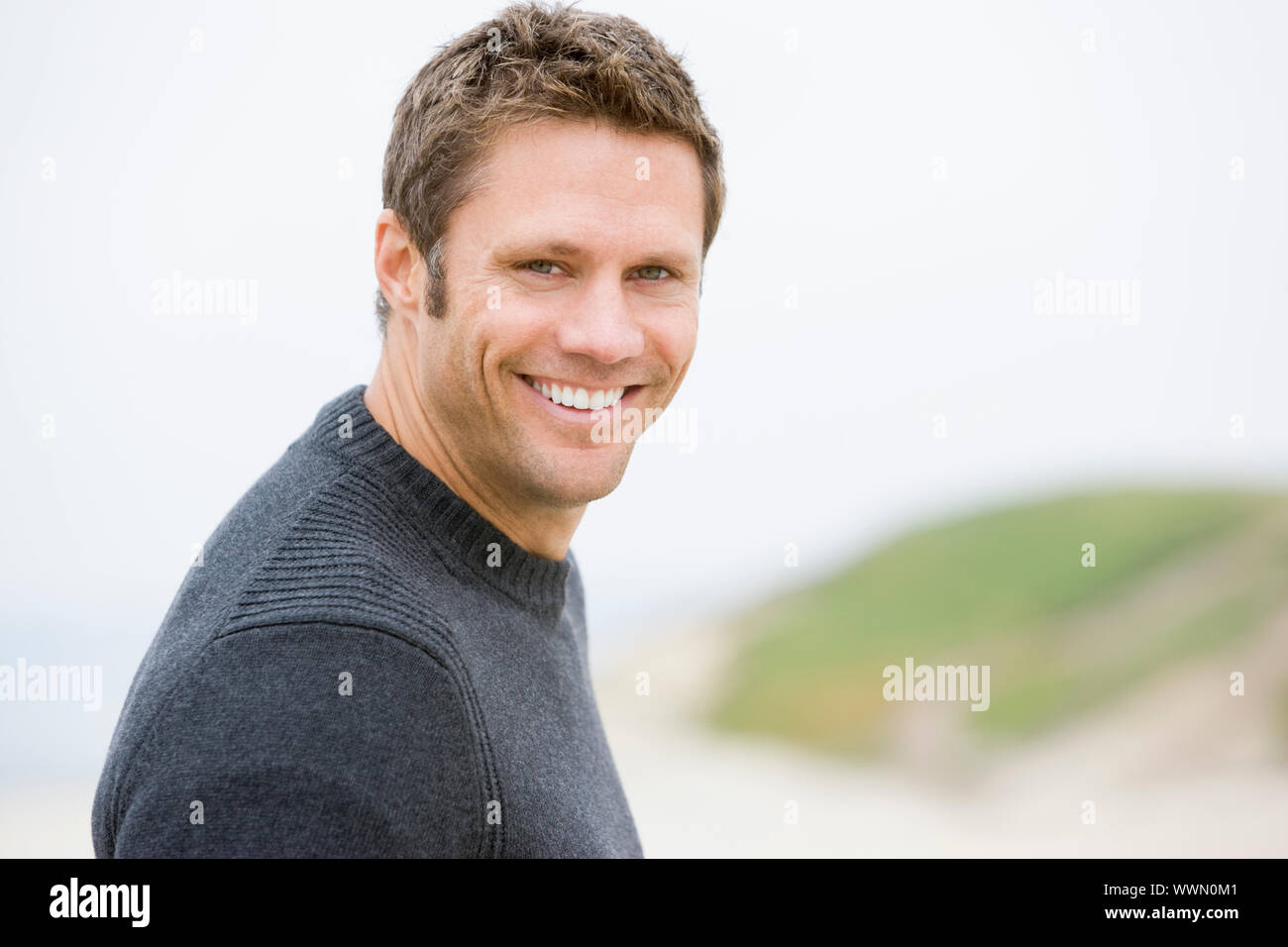 Man standing at beach smiling Stock Photo - Alamy