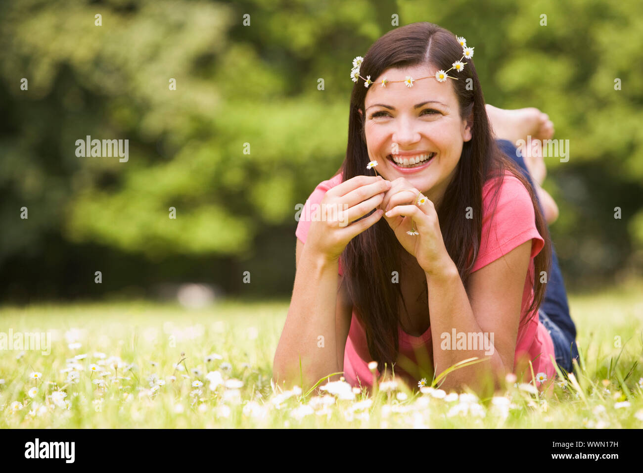 Woman lying outdoors with flowers smiling Stock Photo - Alamy