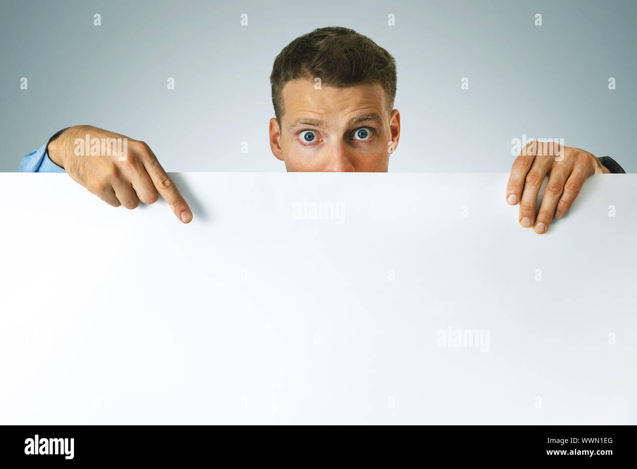 surprised man pointing on white blank poster with copy space Stock ...