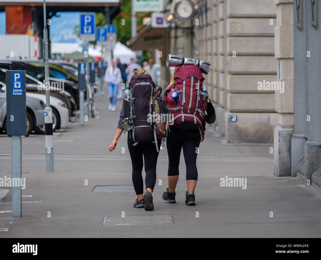 Two female backpackers walking down street in city, back view Stock ...